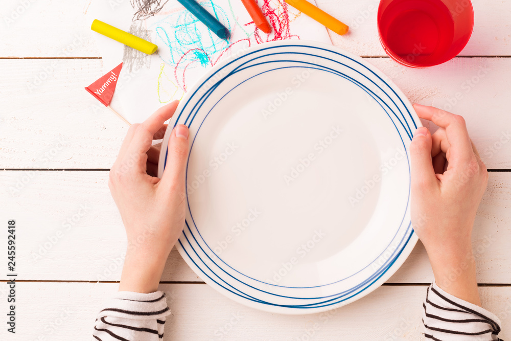 Table setting for kids - empty plate in child's hands Stock Photo ...
