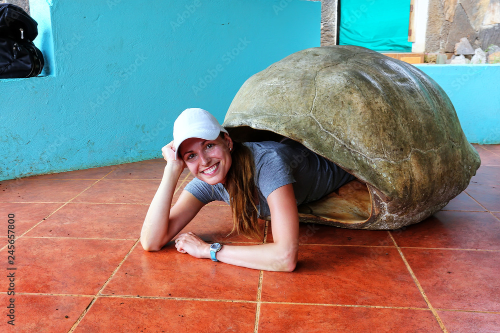Woman lying inside empty Galapagos giant tortoise shell at the ...