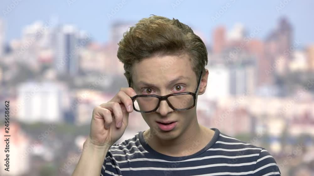 Thoughtful teen boy adjusting his eyeglasses. Surprised nerdy boy in ...