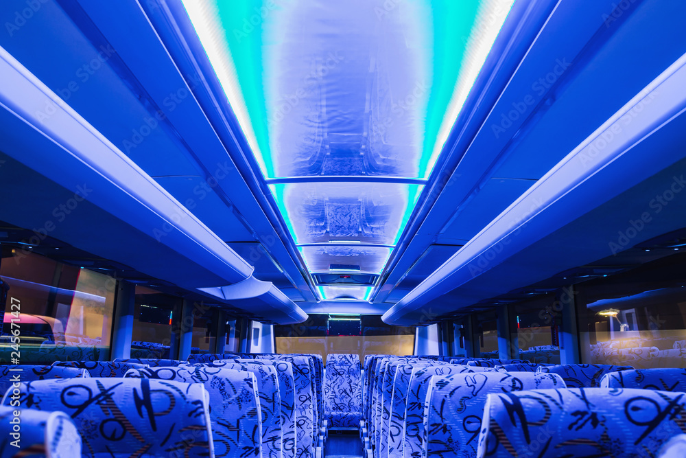 salon and armchairs in a tourist or city bus or electric bus. blue neon ...