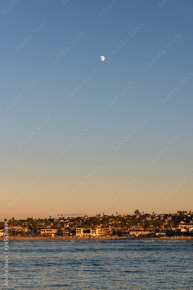 Moon rising over the beach in daytime at Pacific beach, San Diego. Full ...