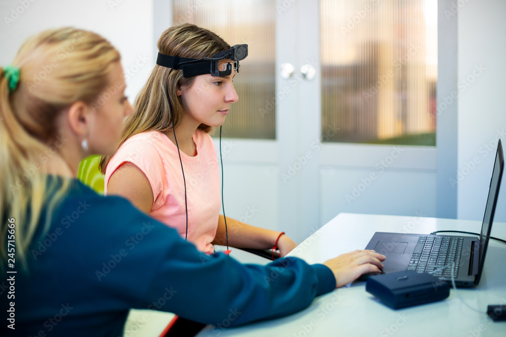 Young teenage girl and child therapist during EEG neurofeedback session ...