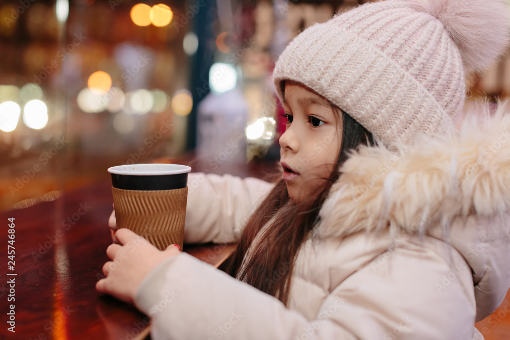 Cute happy little girl drinks hot tea in a street cafe Stock Photo ...