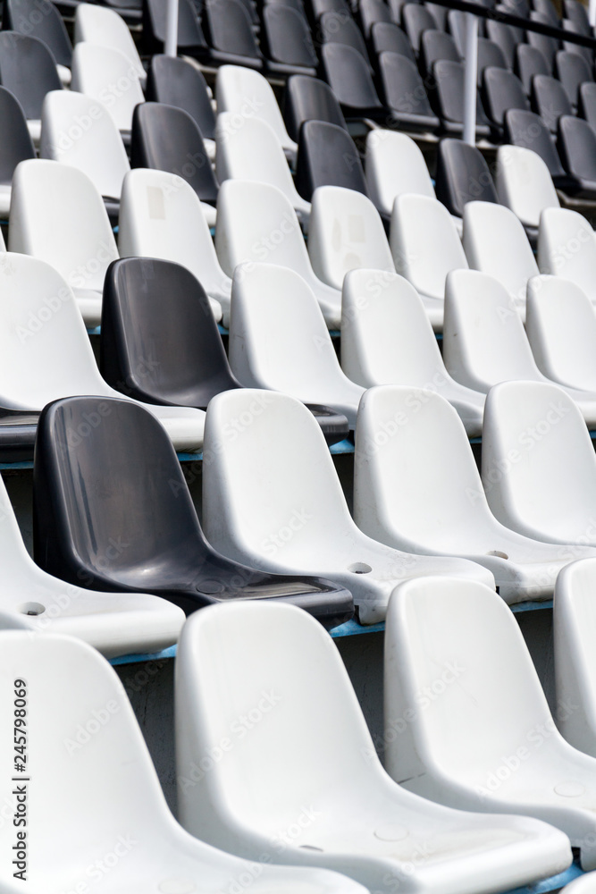 Empty black and white stadium seats mixed in rows, diversity concept ...