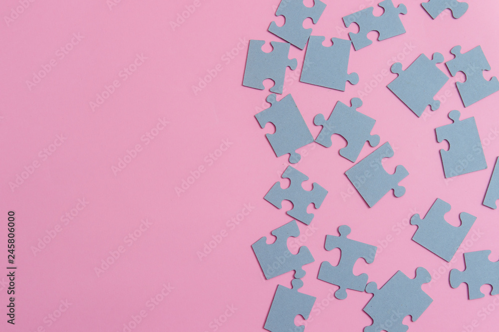Puzzles on a pink background as a symbol of autism. Conceptual vision ...