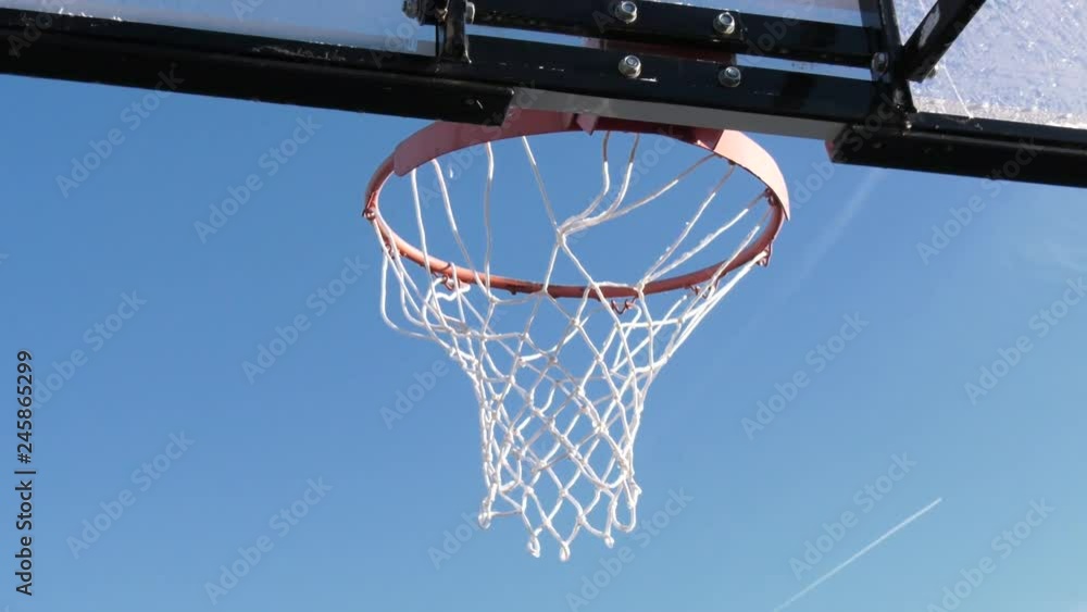 throw in a basketball hoop against a blue sky. Throwing ball into ...