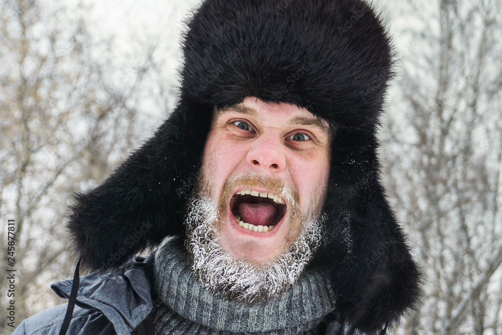 frozen sick grandfather in the woods in a hat with earflaps in the ...