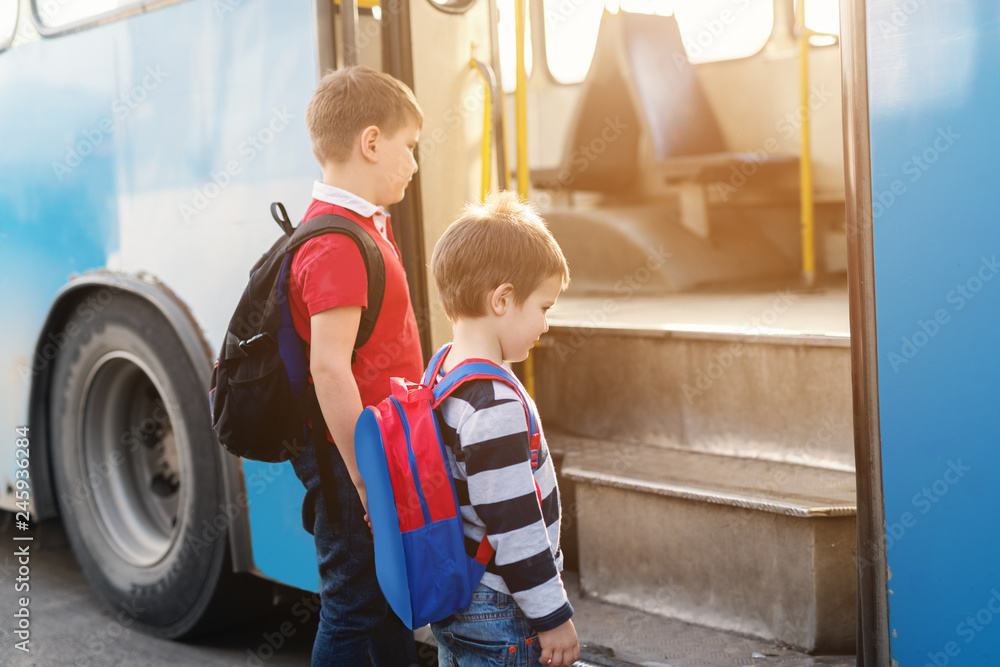 Brothers entering the city bus and going to school. Side view. Stock ...