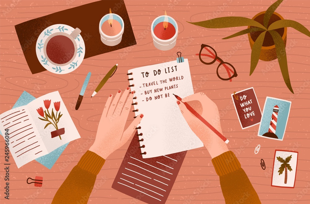 Woman s hands holding pen and writing down goals to achieve in notepad ...