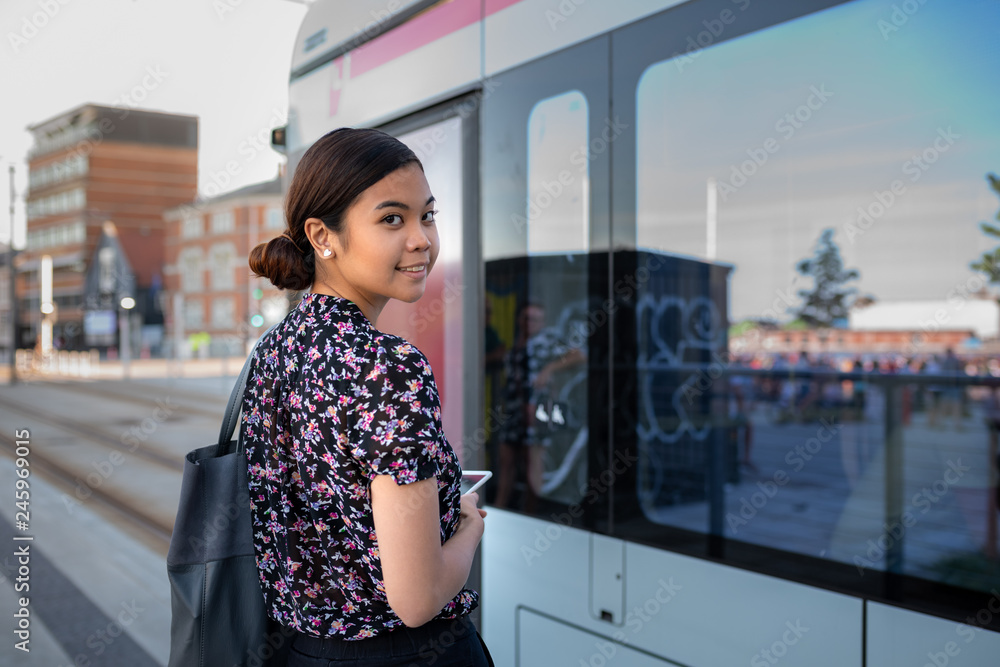 Smiling young Asian businesswoman boarding a bus in the city Stock ...