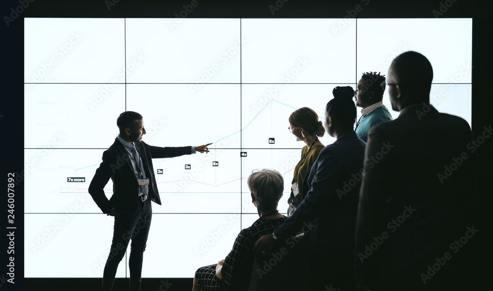 Indian businessman pointing at digital screen during a presentation ...