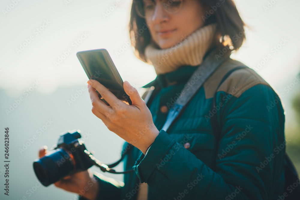 Close up image of pretty brunette girl using her mobile phone while ...