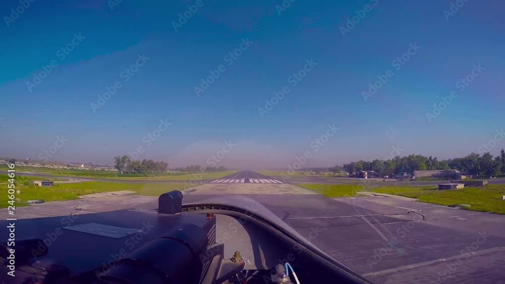 Fighter jet landing at the runway, green grass and trees with runway ...