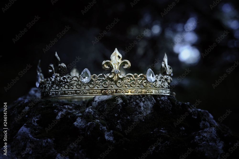 mysterious and magical photo of gold king crown over the stone covered ...