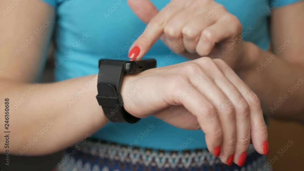Woman using her smartwatch touchscreen wearable technology device. Girl ...