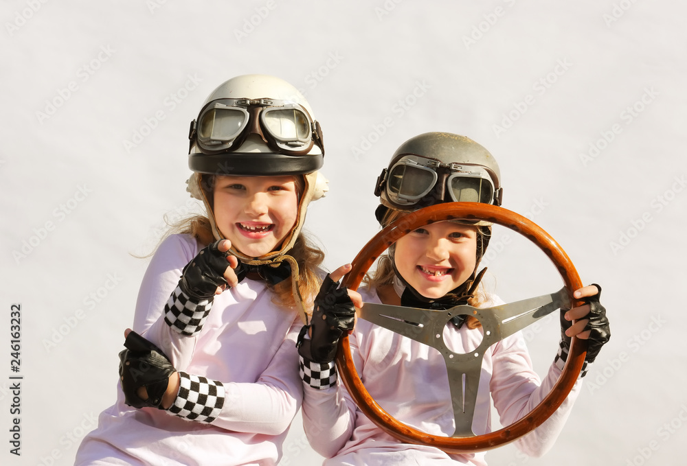 Twin sisters play race car driver sitting in their imaginative sports ...
