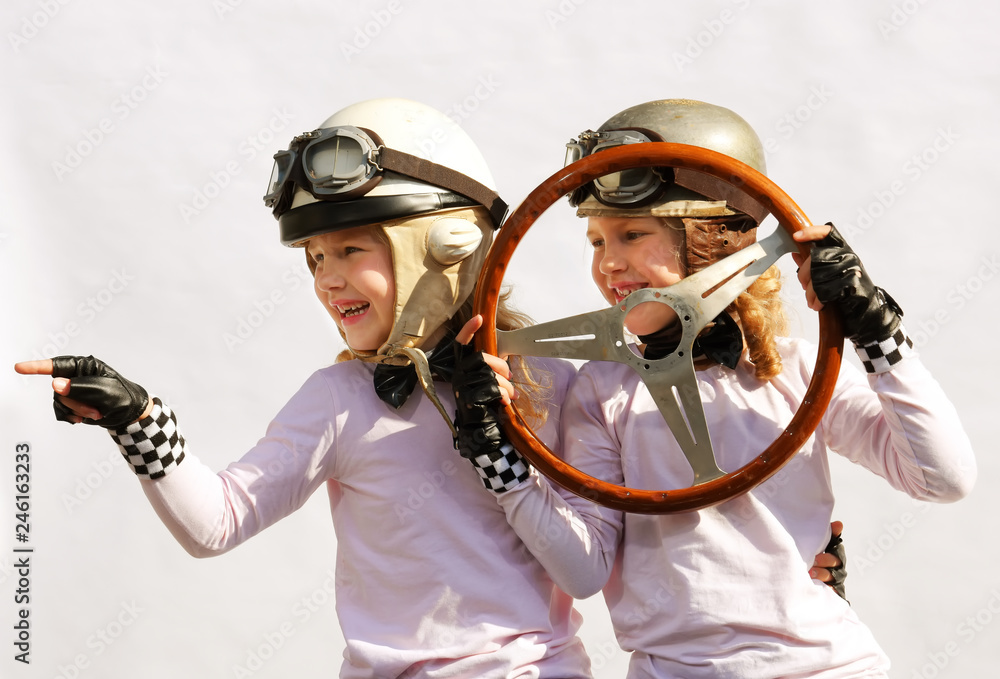 Foto de Twin sisters play race car driver sitting in their imaginative ...