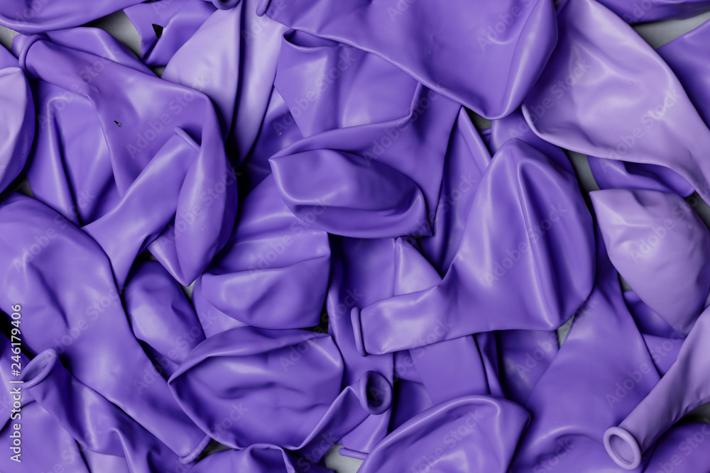Pile of deflated purple balloons on a white background. Clean pure ...