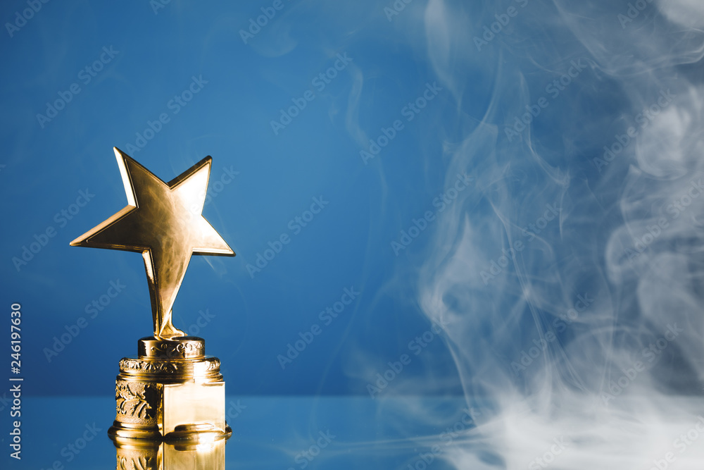 gold star trophy in smoke, blue background Stock Photo | Adobe Stock