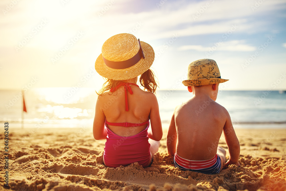 children boy and girl in swimsuit sit on beach back. Stock Photo ...