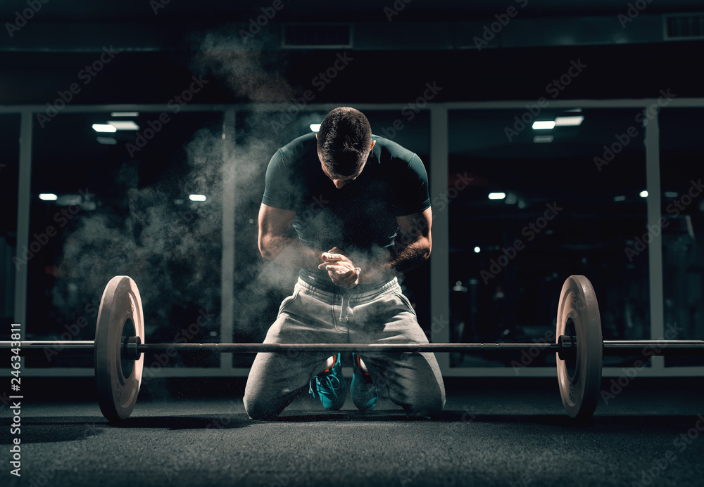 Caucasian muscular man kneeling and clapping hands. In front of him ...