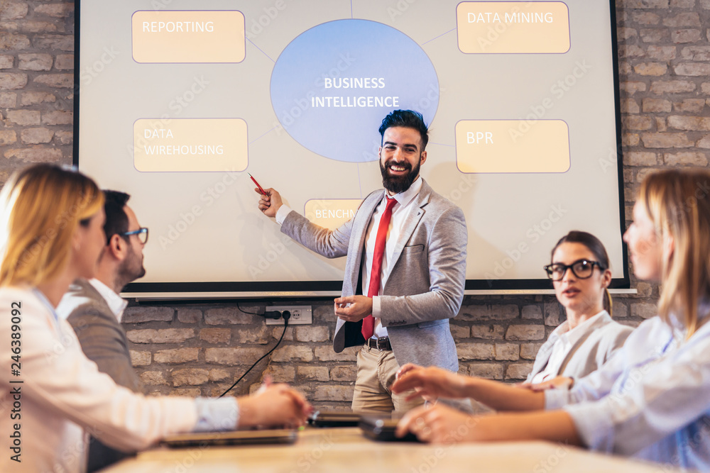 Confident speaker giving public presentation using projector in ...