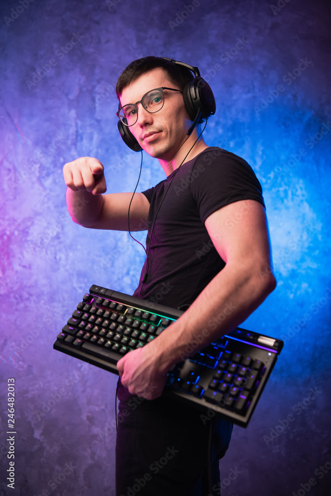 Young handsome gamer wearing headset with microphone, holding a ...