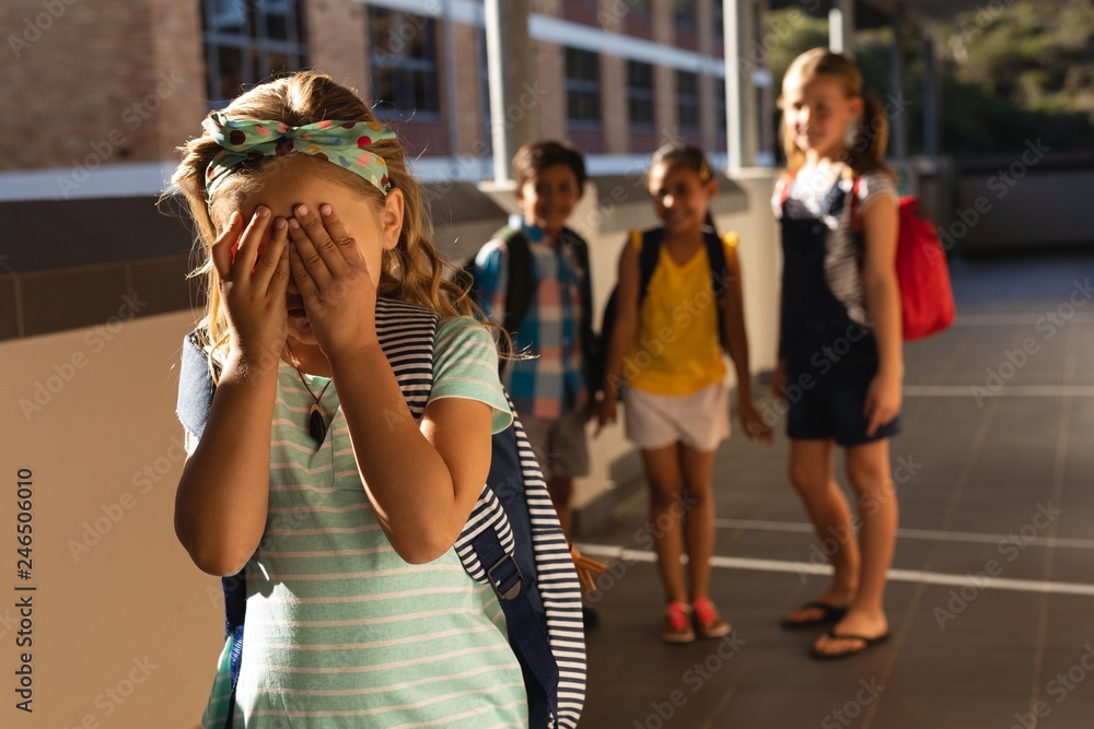 School friends bullying a crying girl in hallway of elementary Stock ...