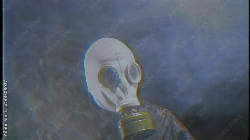 Man wearing a gas mask sitting with smoke around him. VHS tape look ...