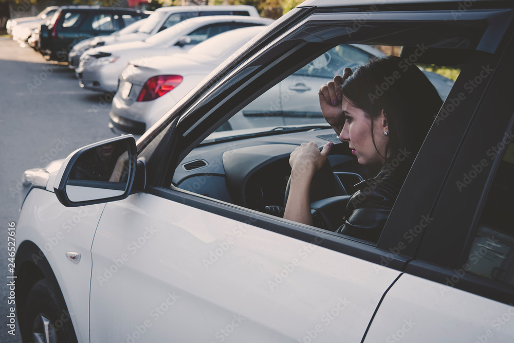 Side view of beautiful young woman looking in car side-view mirror ...