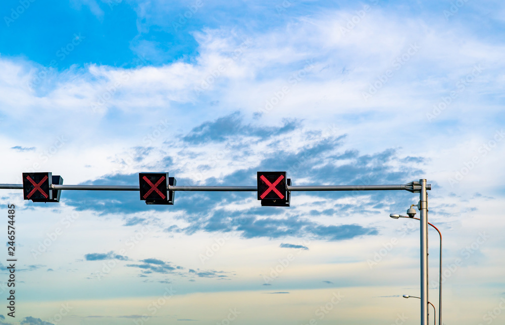 Traffic signal light with red color of cross sign on blue sky and white ...