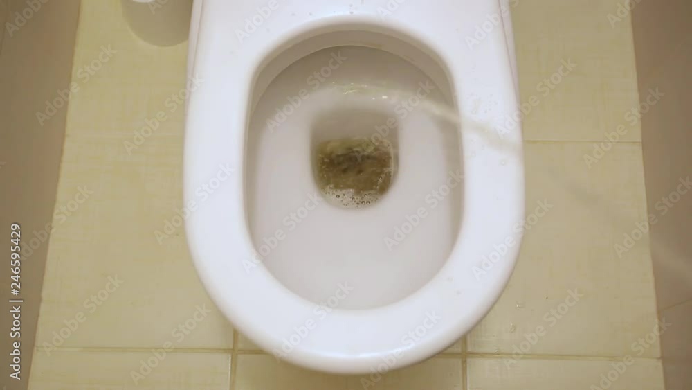 Man peeing to toilet bowl in restroom. Stream of urine flows into the ...