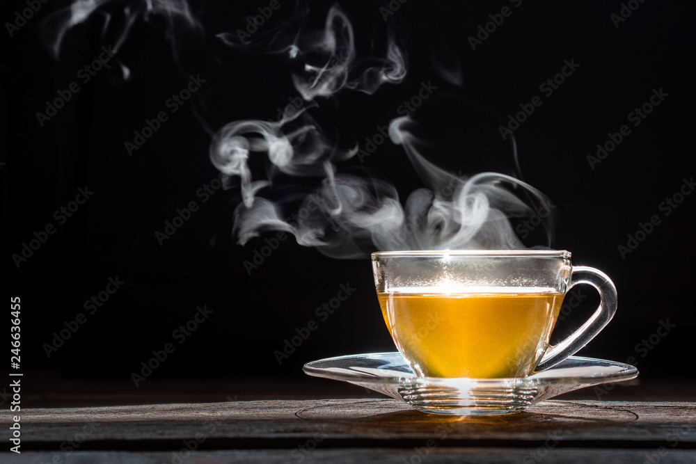 A Cup of freshly brewed green tea,with steam,warm soft light, dark ...