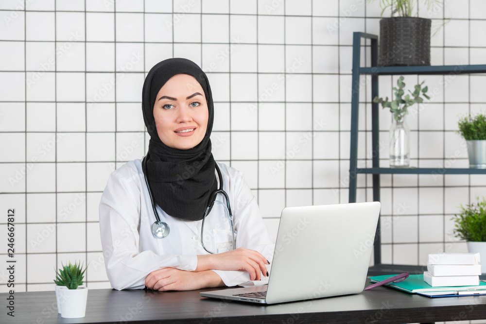 Muslim female doctor writing report on her working desk Stock Photo ...