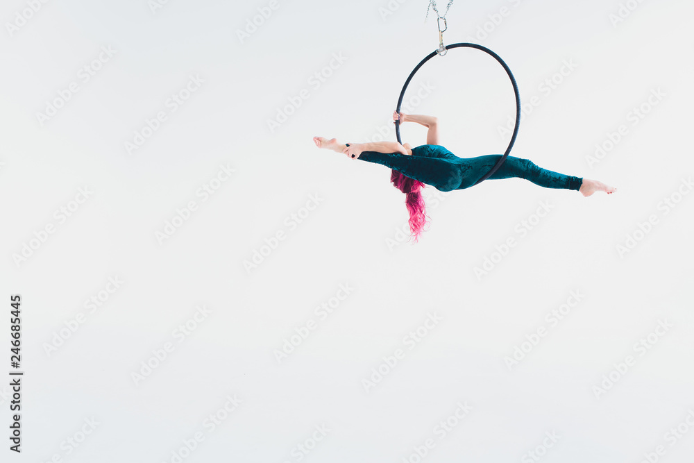 Aerial acrobat in the ring. A young girl performs the acrobatic ...