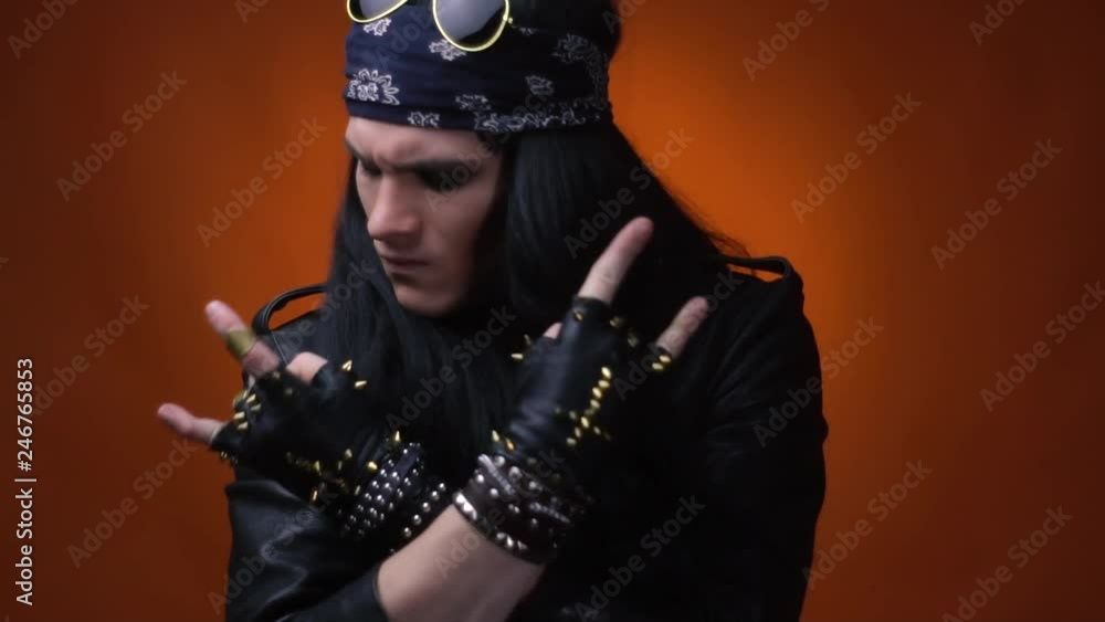 Rocker guy jamming out to music and showing the sign of the horns, slow ...