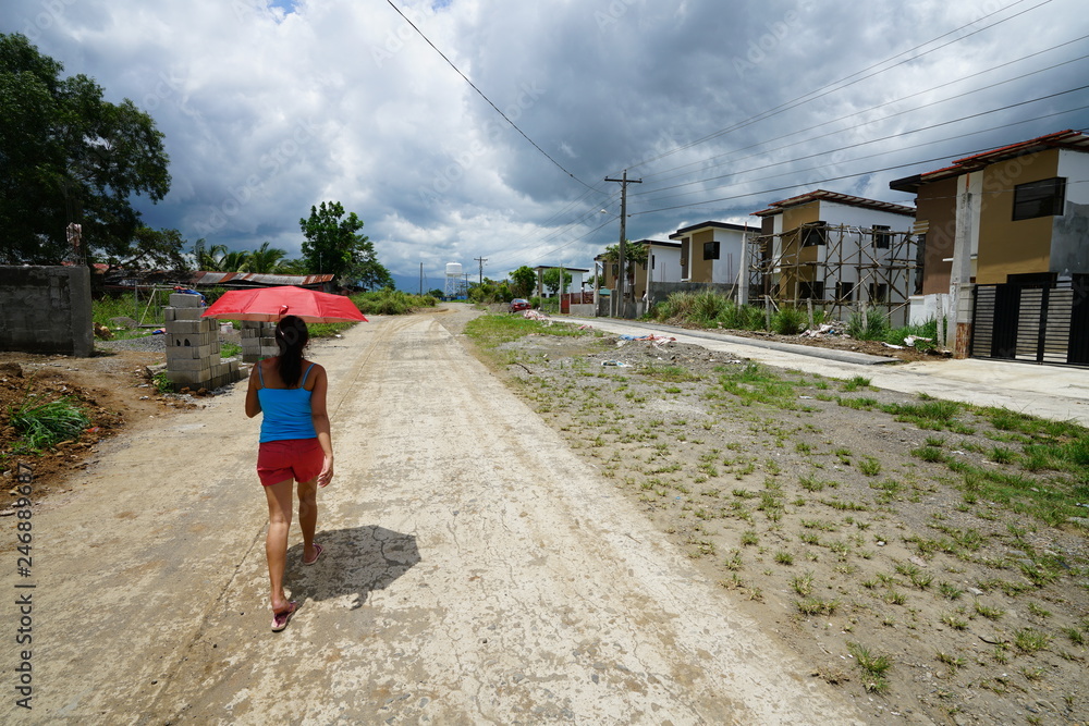 Filipina woman walking along the street in a neighborhood of Bacolod ...