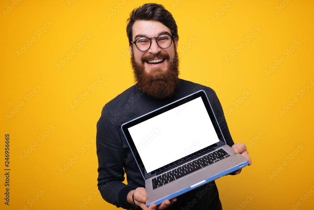 Happy man in gray shirt showing laptop computer screen at the camera ...