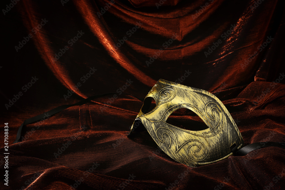 Photo of elegant and delicate gold venetian mask over dark velvet and ...