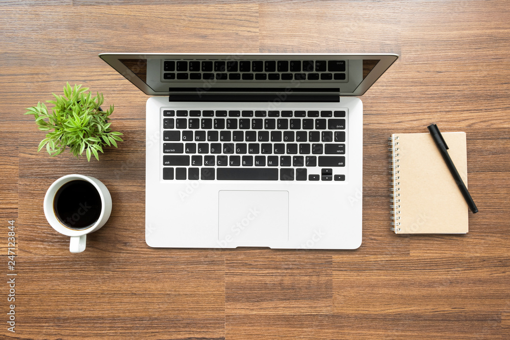 Wood office desk table with laptop computer, cup of coffee and office ...