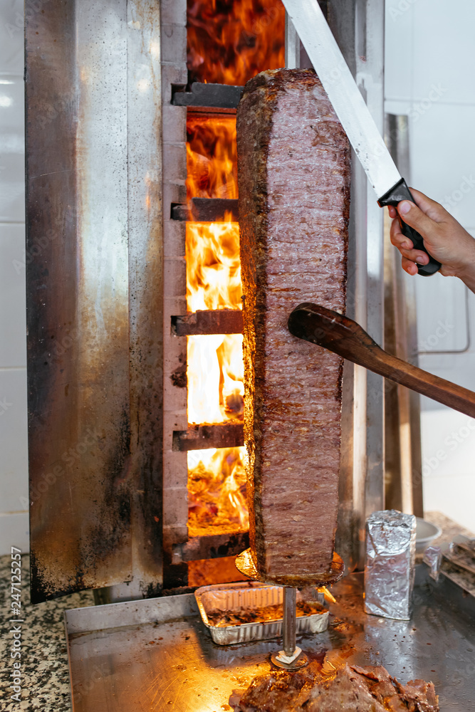 Turkish Doner Kebab, Shawarma or Gyros. Chef cutting with doner knife ...