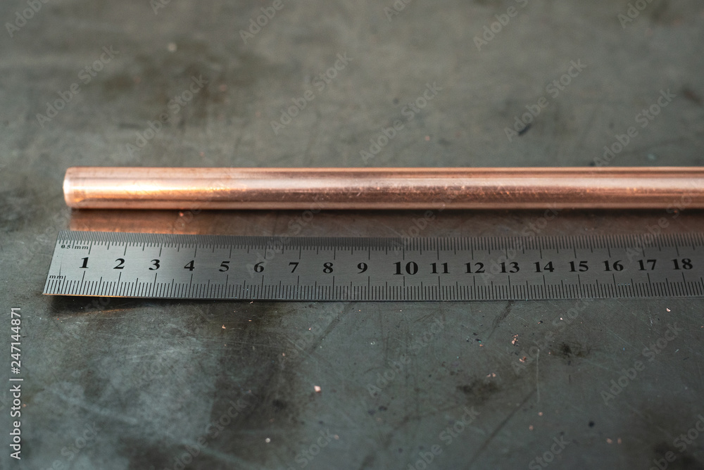 Pipe and straightedge on a fitter workbench background. Measuring of a ...
