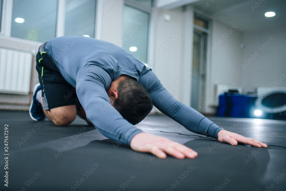 Low angle image of muscular man stretching back indoors. Stock Photo ...
