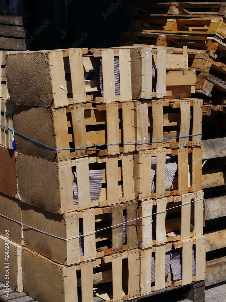 Fruit and vegetable crates tied together and stacked. Stored on a ...