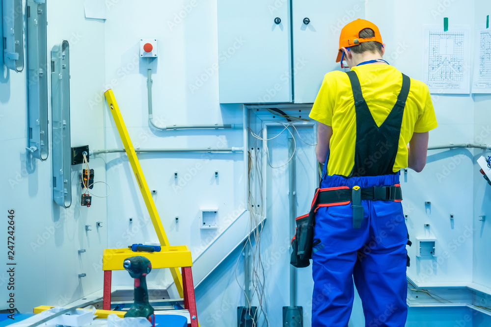 Electrician repairs wiring. Electrical wiring in the cable channel ...