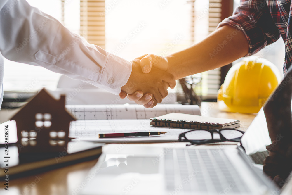 Client shaking hands with contractor after confirm blueprint to ...