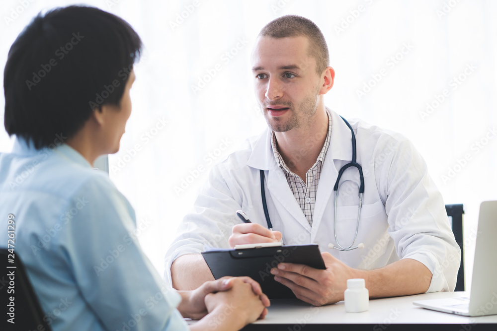 Doctor listening patient explain his symptom and notes to medical ...