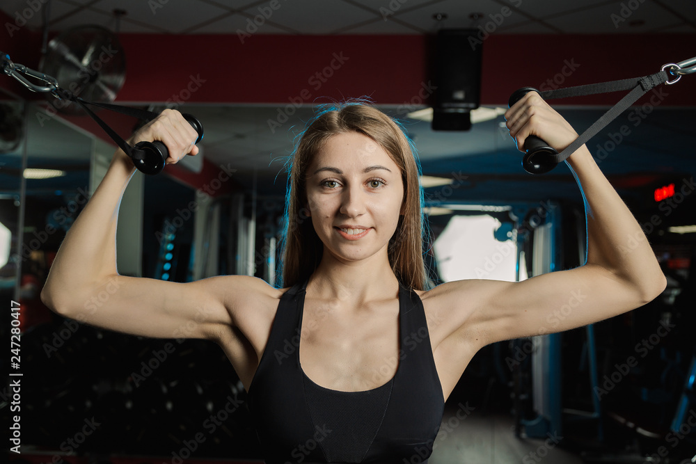 Active beautiful fitness model girl trains biceps on the block in the ...