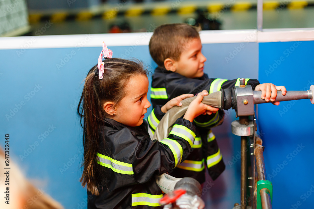 Foto de Little boy and girl in fireman costume playing, pretend to be a ...