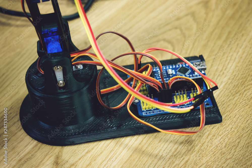 3D printed robot arm with wires and control board. Plastic manipulator ...